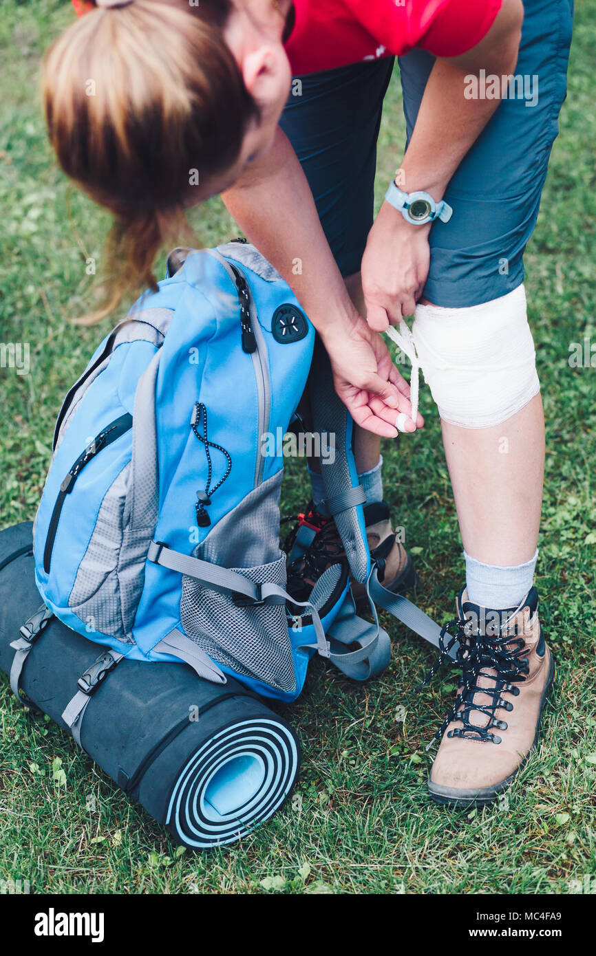 Woman injured in the accident on mountain hike. Bandaging the wound on ...