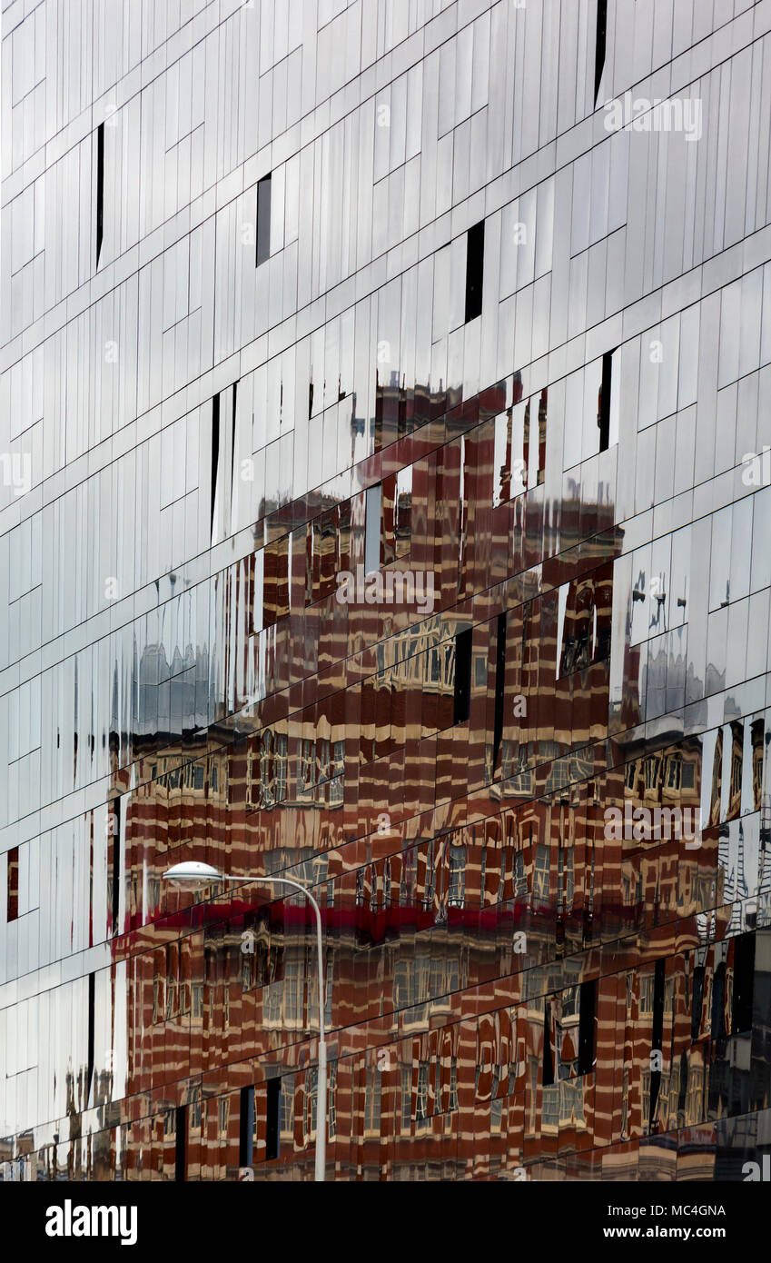 An old Victorian building's reflection on a modern glass building in ...