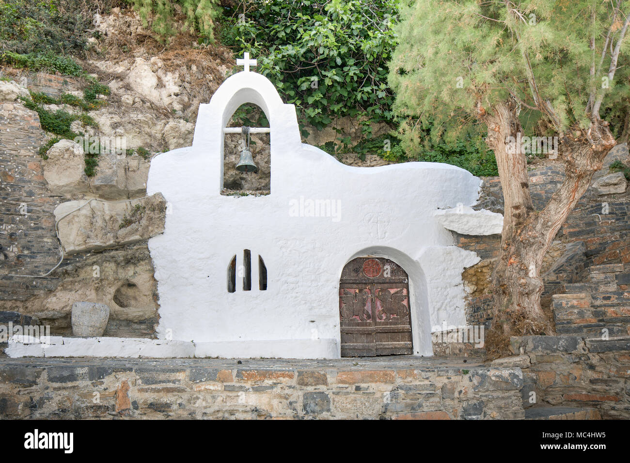 Little orthodox chapel carved in rocks, lake coast in Agios Nikolaos ...