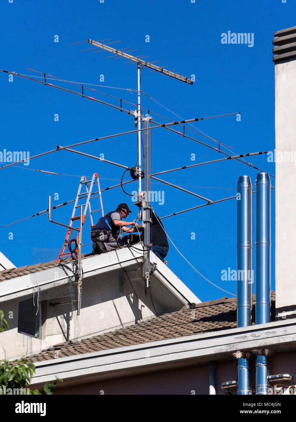 workers on the roof repair TV aerial Stock Photo - Alamy