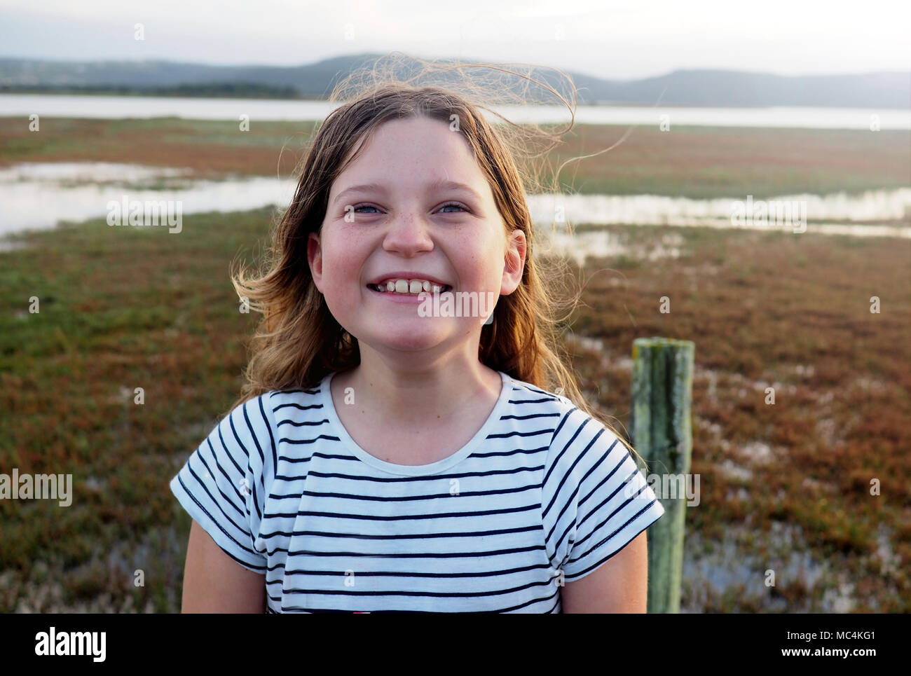Young girl grinning, outdoors on holiday Stock Photo - Alamy