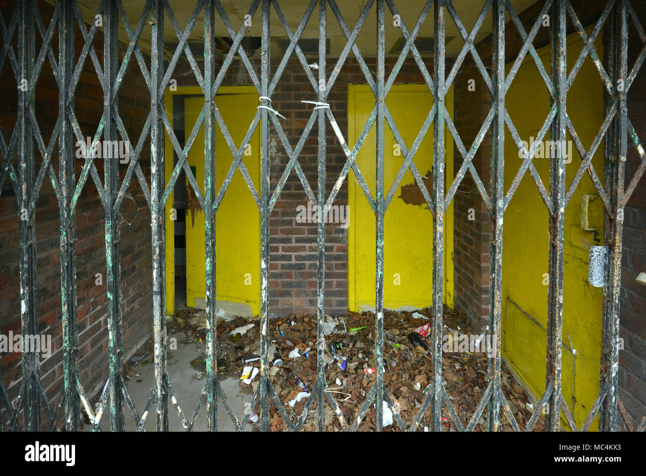 Vandalised yellow doors in a fenced off building, Newhaven, East Sussex ...