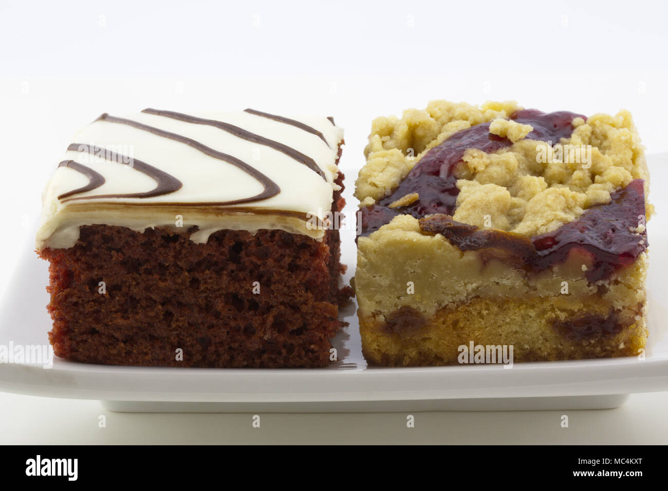Side by side square slices of two different cakes, raspberry crumb cake ...