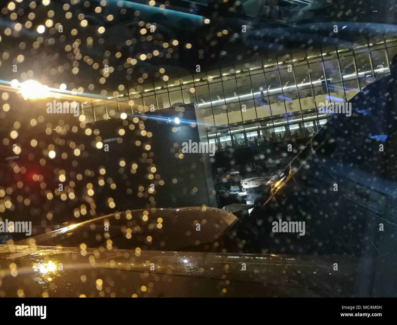 Looking through cabin window on rainy night outside airplane to ...