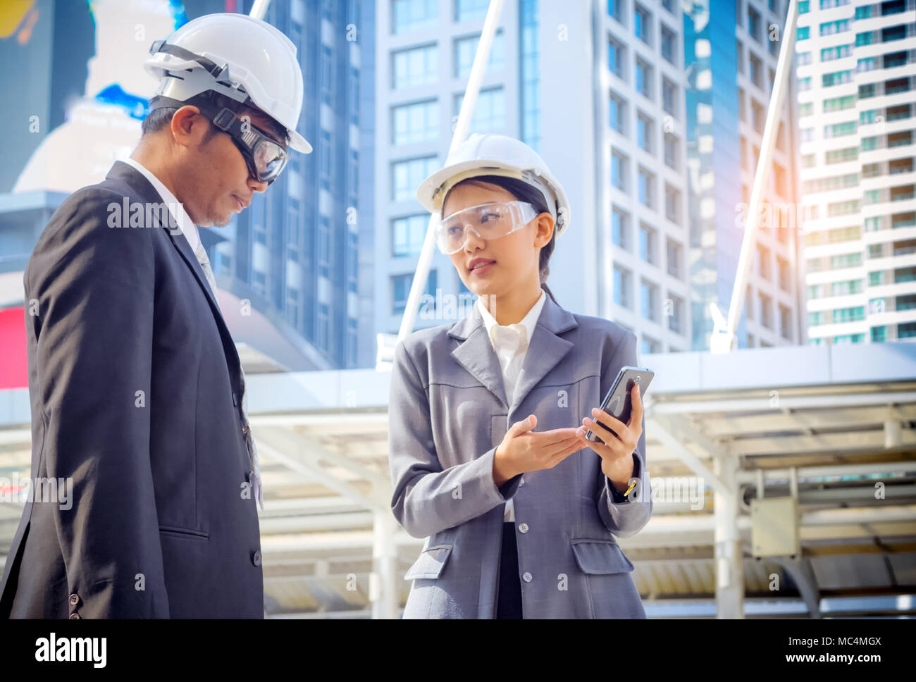 Construction manager and engineer working with smart phone on building ...