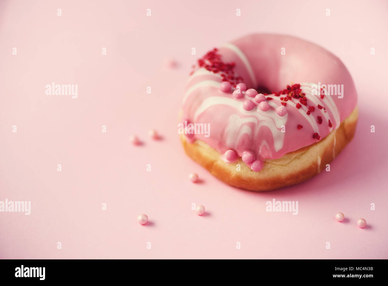 Sweet doughnut with pink icing on pastel background. Tasty donut on ...