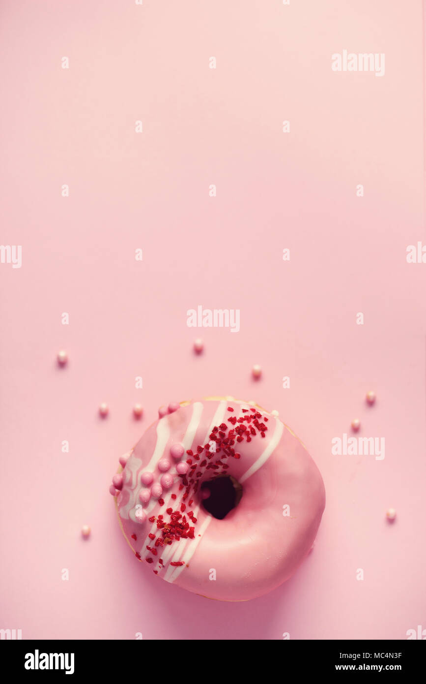 Sweet doughnut with pink icing on pastel background. Tasty donut on ...