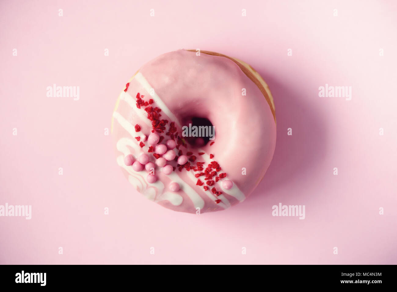 Sweet doughnut with pink icing on pastel background. Tasty donut on ...