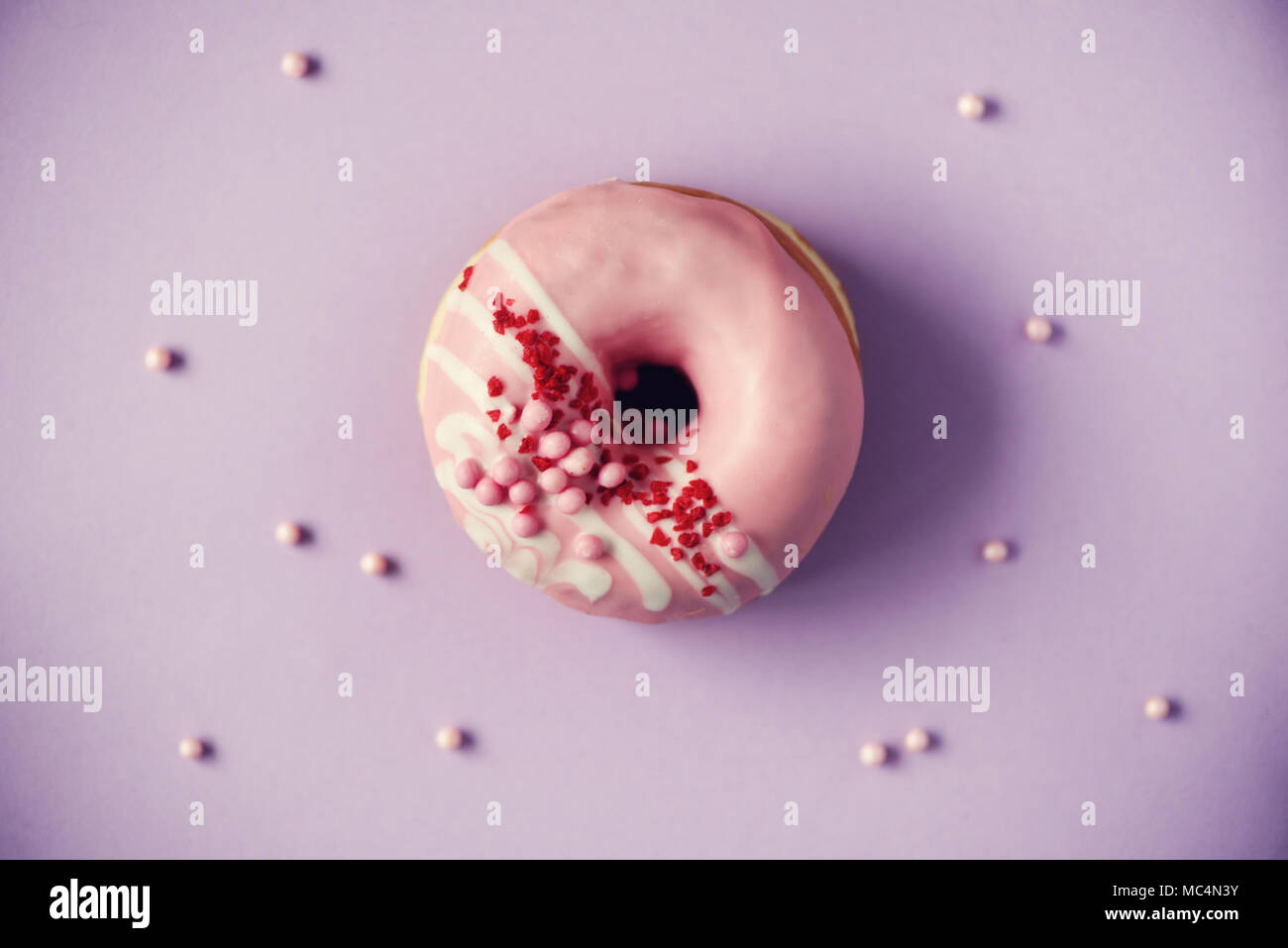 Sweet doughnut with purple icing on pastel background. Tasty donut on ...