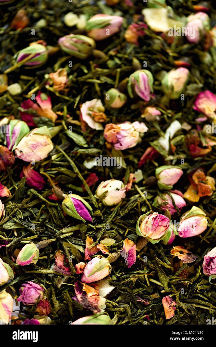 Texture of green tea with rose petals. Dried rosebuds background ...