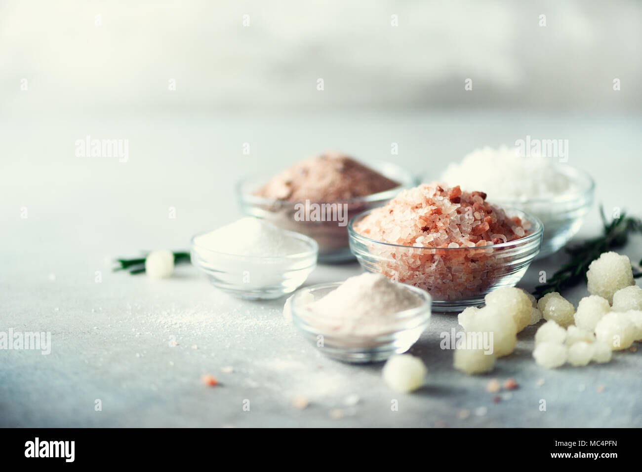 Mix of different salt types on grey concrete background. Sea salts ...