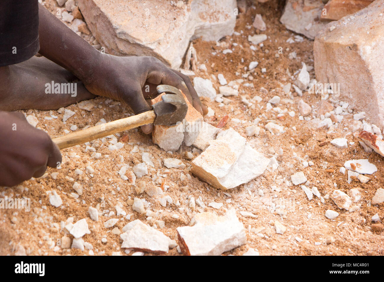 Ugandan child's hands breaking rocks into small slabs for his or her ...