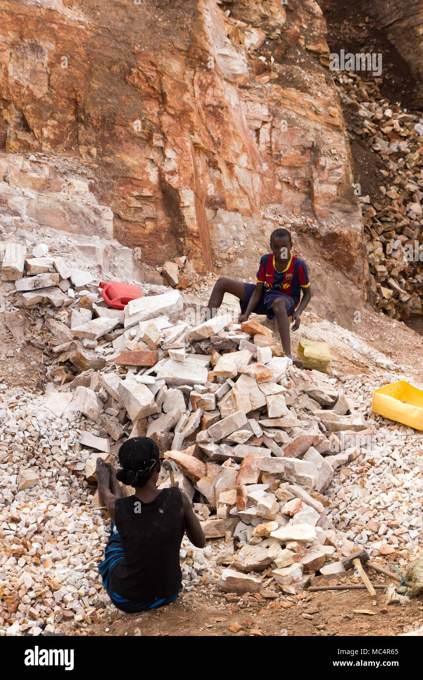 Lugazi, Uganda. June 18 2017. A Ugandan woman and boy breaking rocks ...