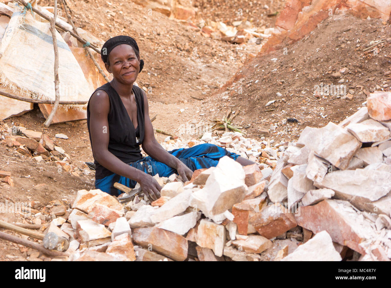 Lugazi, Uganda. June 18 2017. A Ugandan woman breaking rocks into small ...