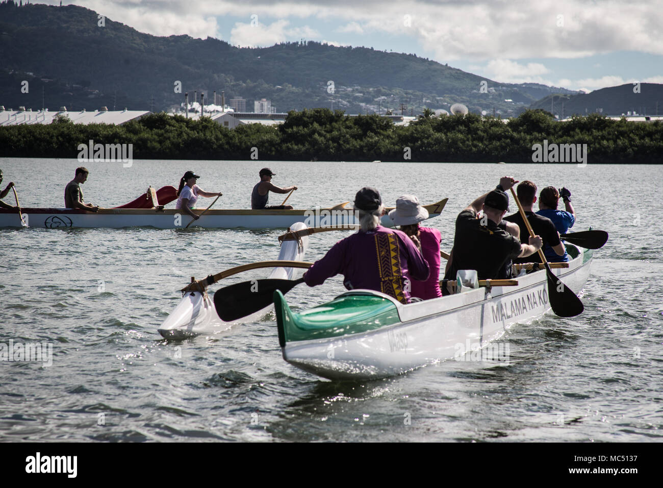 Outrigger canoeing boat teams paddle into the water at the start of the ...