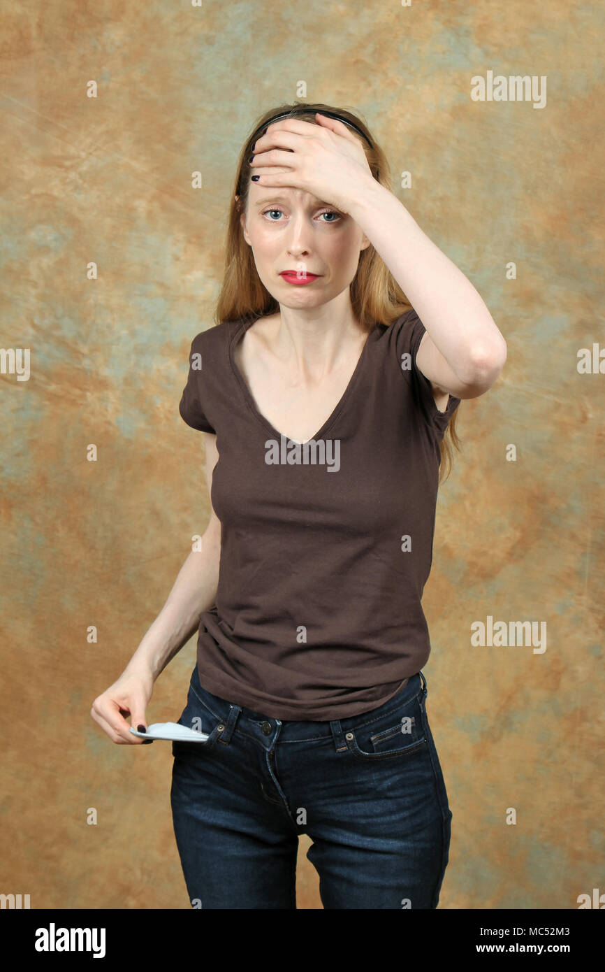 Young woman showing empty pocket with worried face expression and arm ...