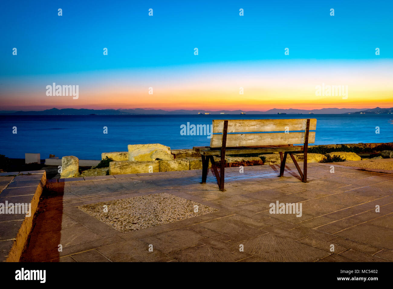 Bench face in the sea on summer time and with a beautiful sunset and ...