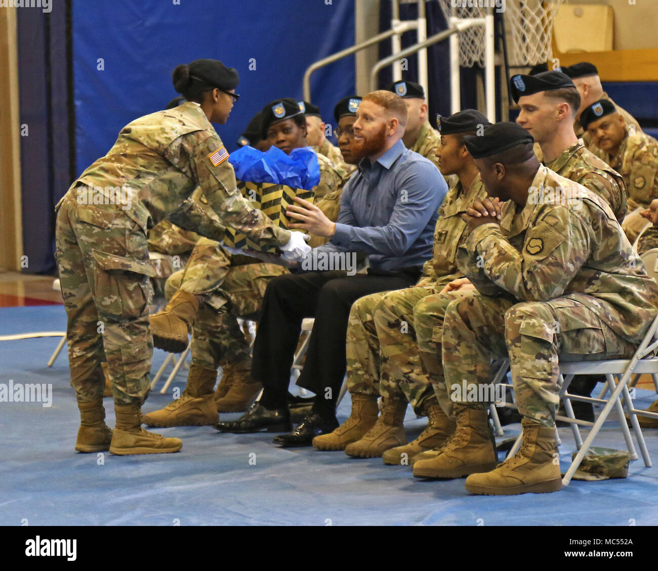 Pvt. 1st Class Andrea S. Jordan hands a gift to Eric Hargrove, spouse ...