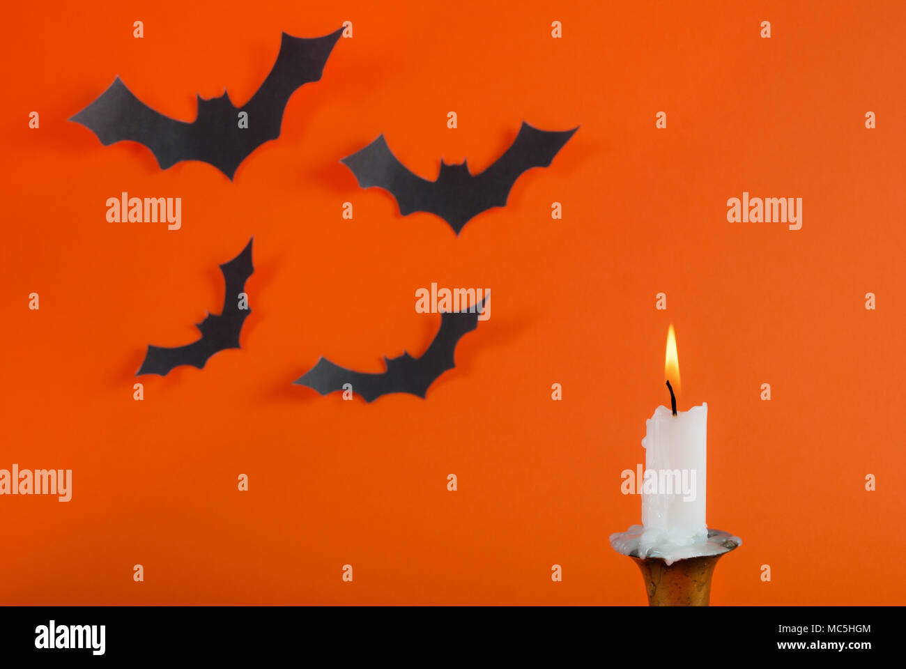 Bats flying and candle burning on orange background with space for ...