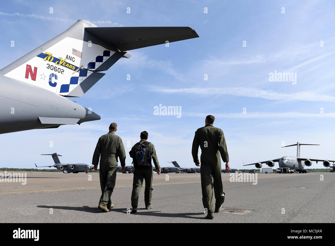 Members of the 156th Airlift Squadron, walk past the memorial tail ...