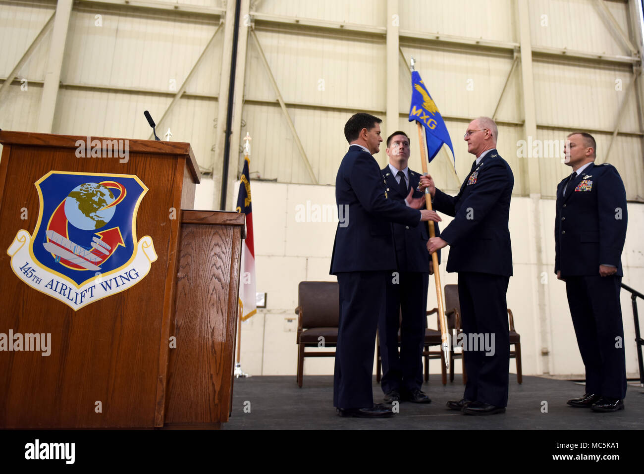 U.S. Air Force Col. Allan Cecil (middle) ceremoniously hands off the ...