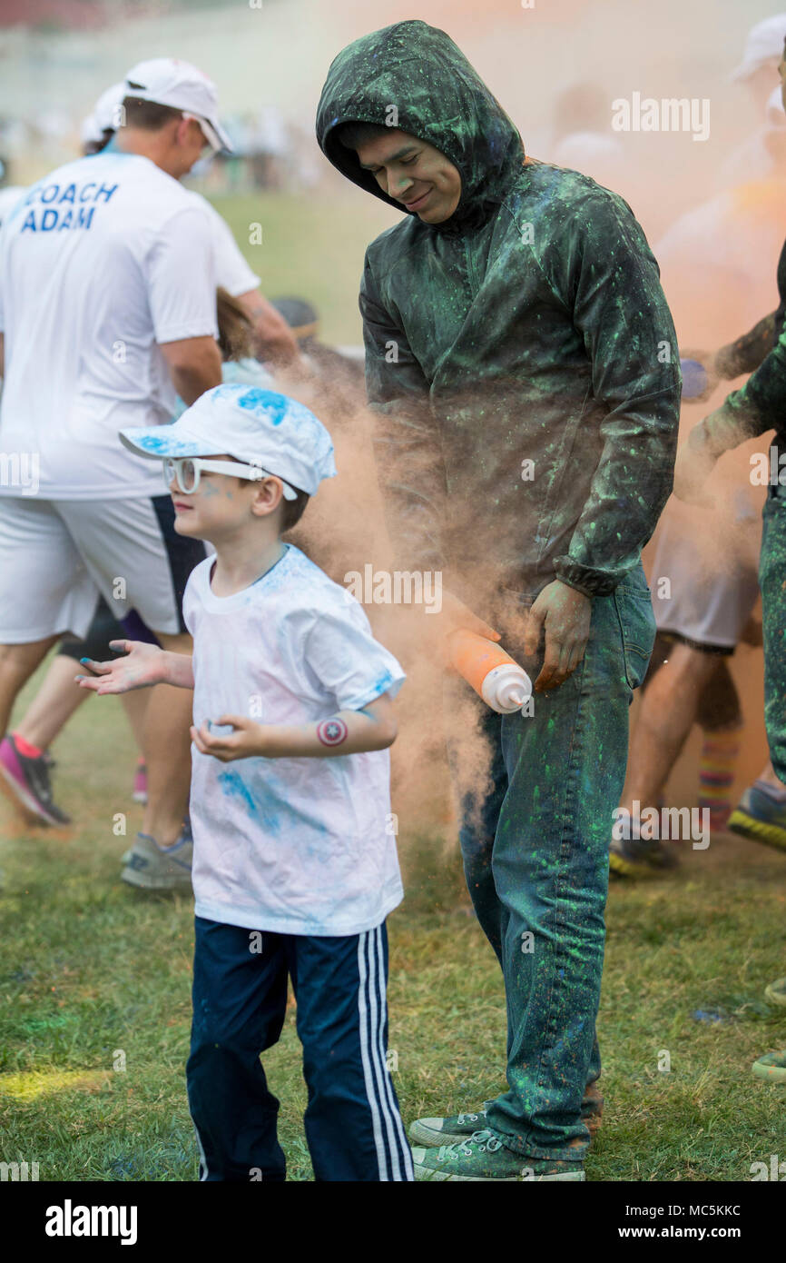 CAMP FOSTER, OKINAWA, Japan – A volunteer sprays a child with paint ...