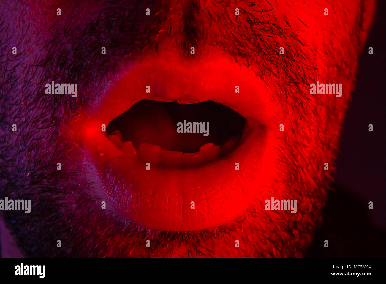 Macro closeup on man with surprised facial expression with opened mouth ...