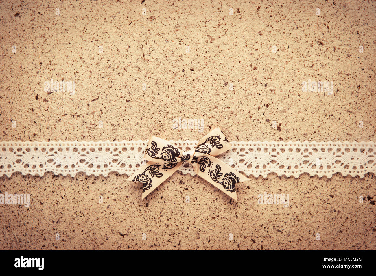 Retro lace and bow over real hand made paper background Stock Photo - Alamy