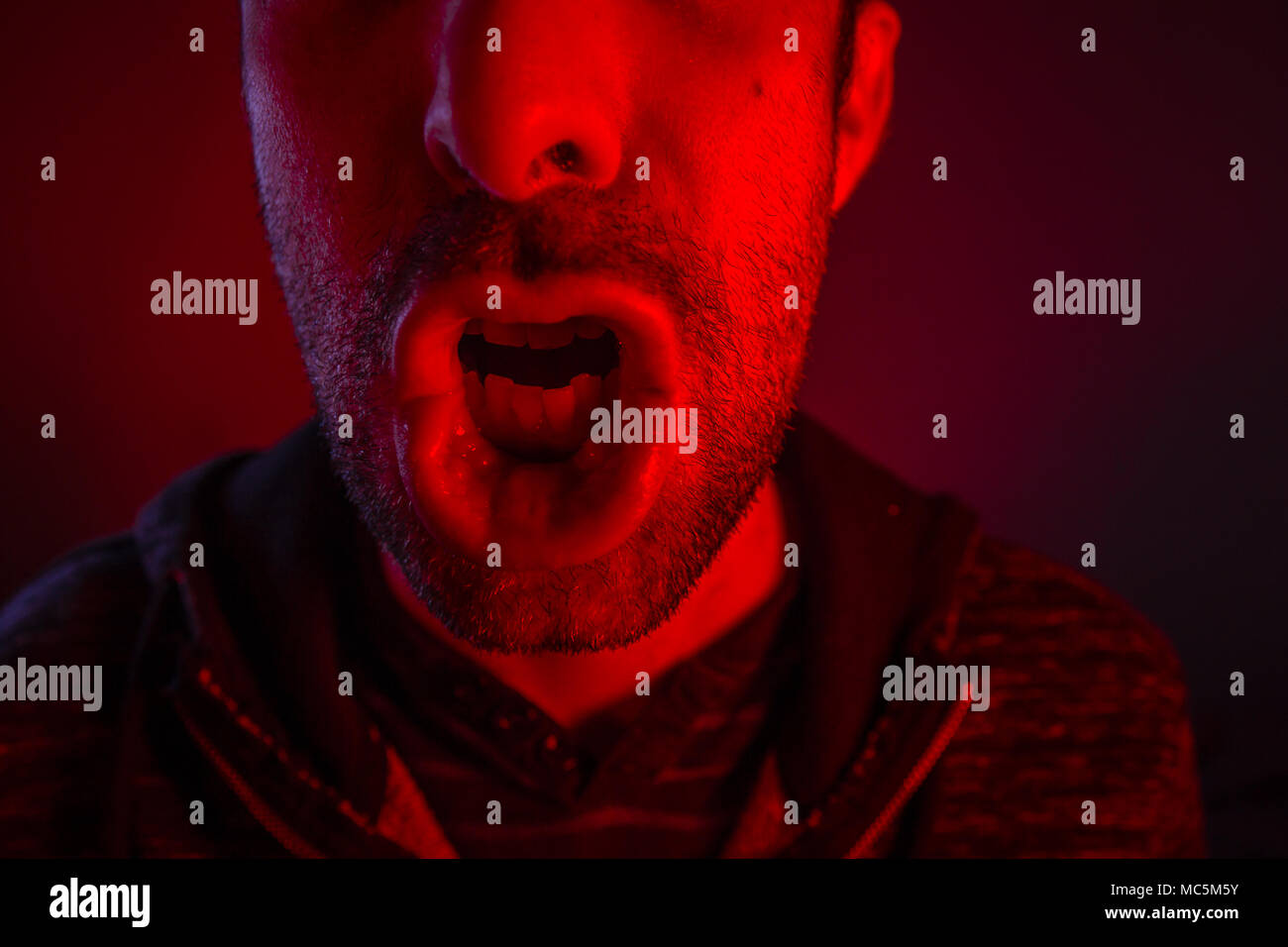 Man with angry facial expression screaming out loud. Close up portrait ...