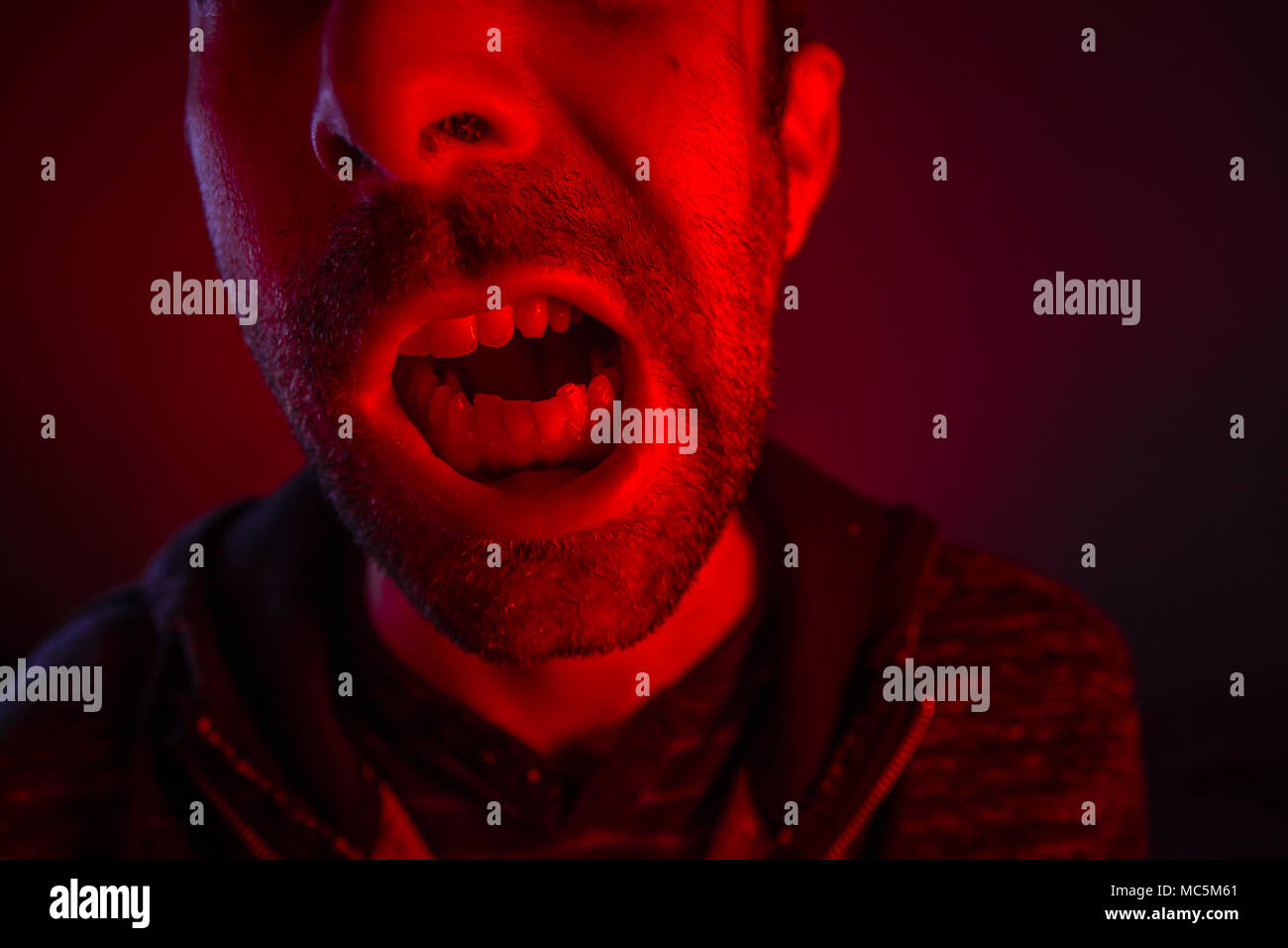 Man with angry facial expression screaming out loud. Close up portrait ...