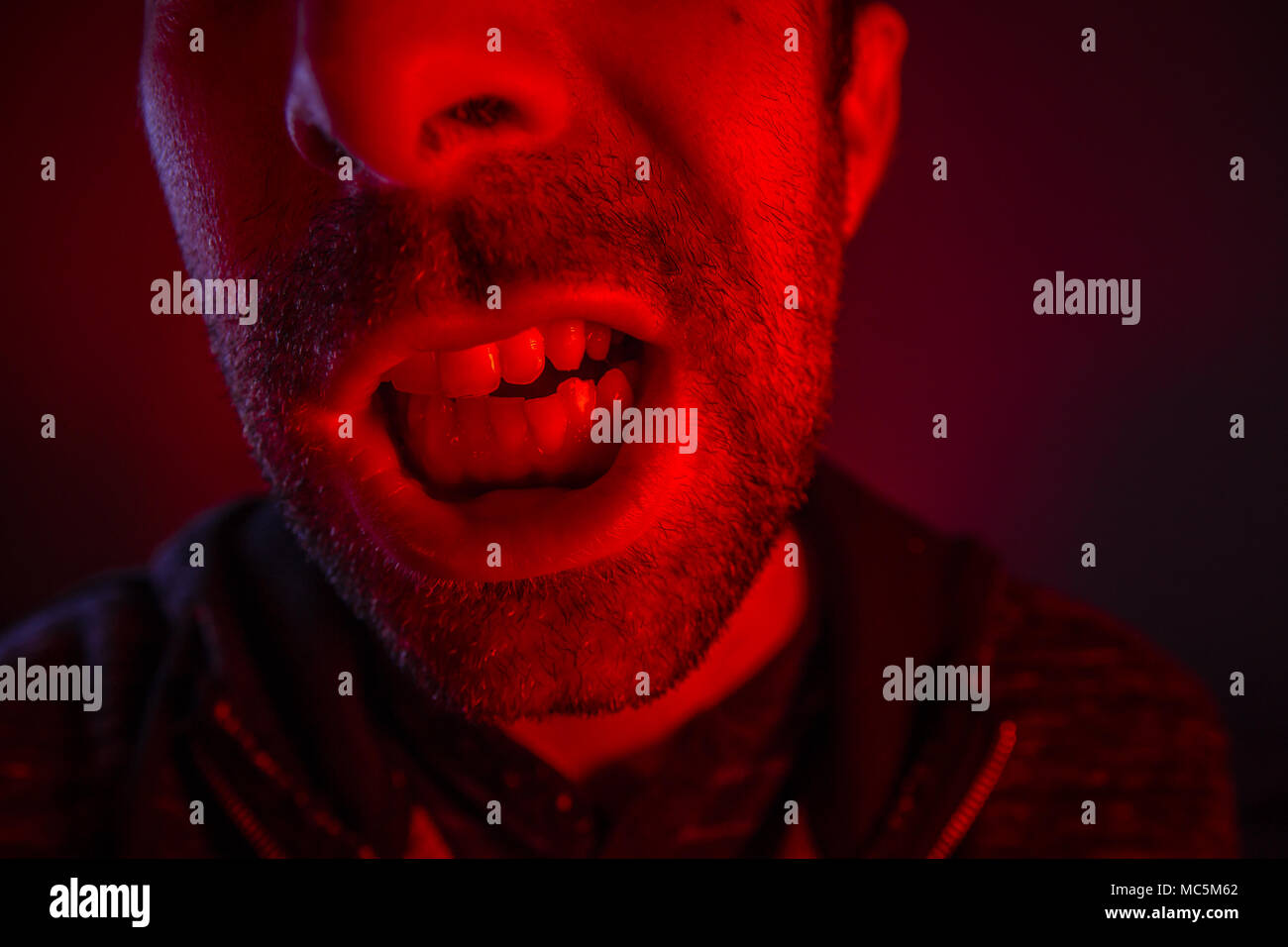 Man with angry facial expression screaming out loud. Close up portrait ...