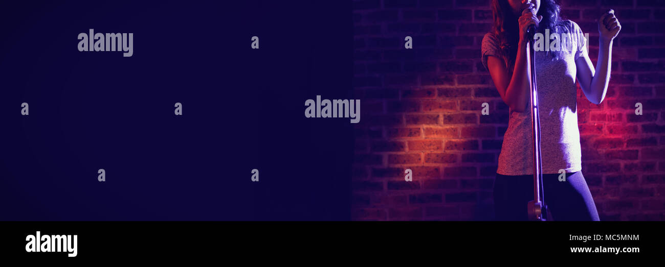 Female singer performing against wall at club Stock Photo - Alamy