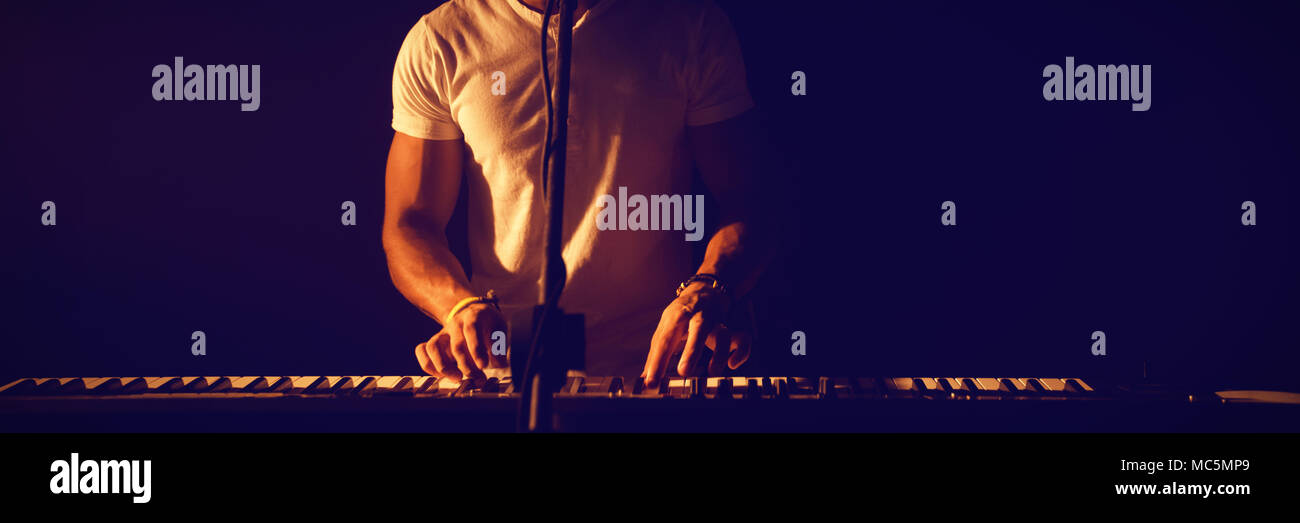 Man singing while playing piano at club Stock Photo - Alamy