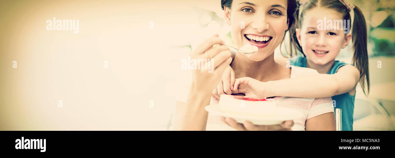 Mother eating slice of cake with daughter Stock Photo - Alamy