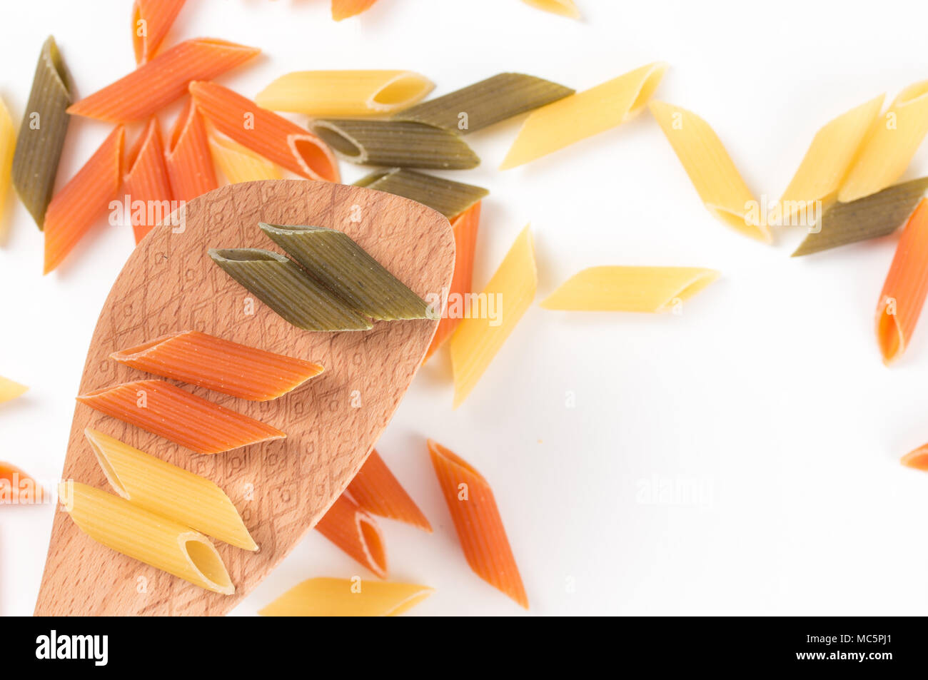 raw tricolour Italian pasta penne with wooden spoon top view Stock ...