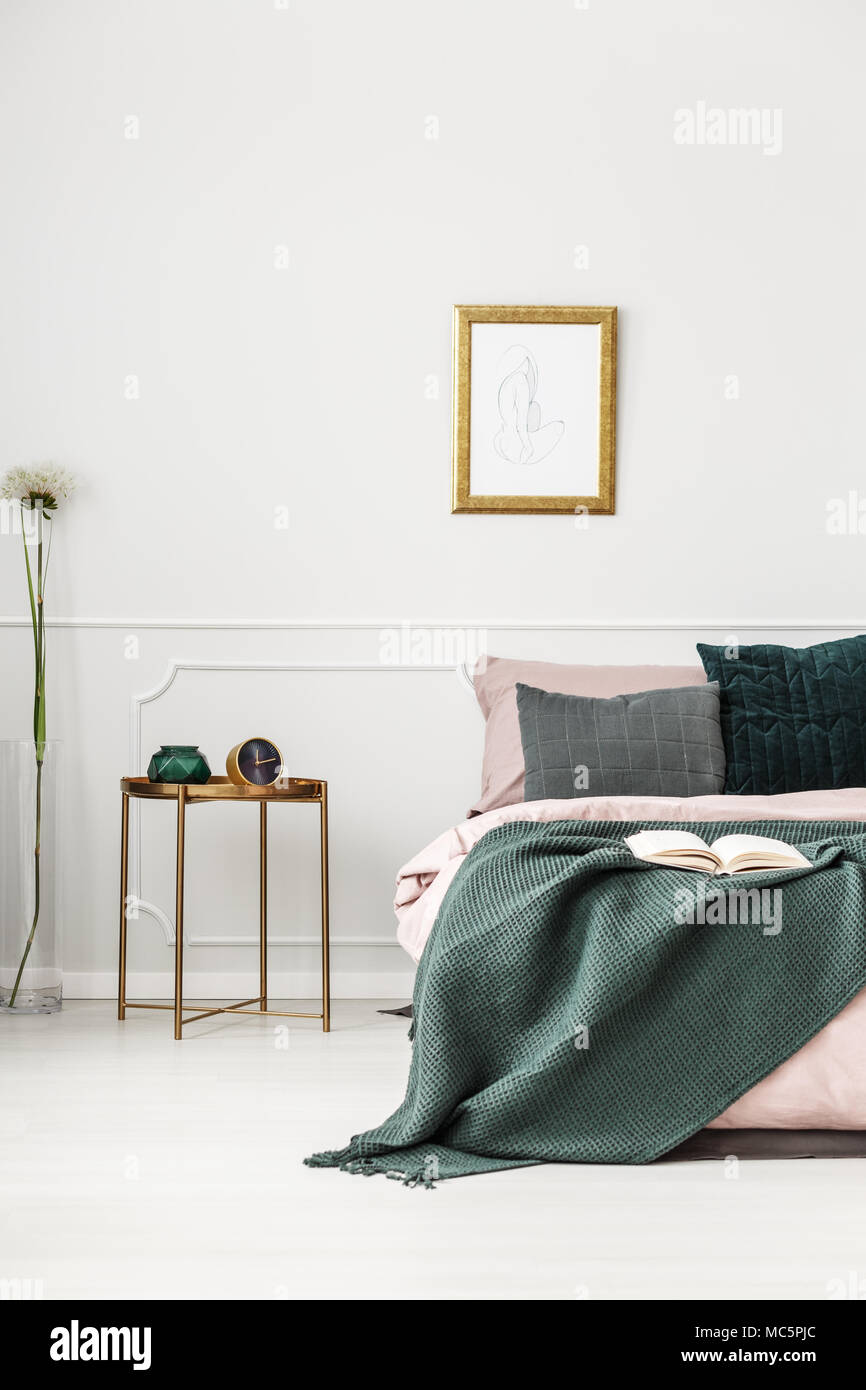 Golden, metal bedside table with clock standing in elegant female ...