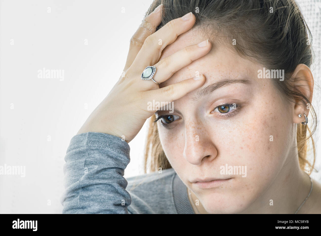 Teenager girl almost to cry, sad at home, with her hand on the forehead ...