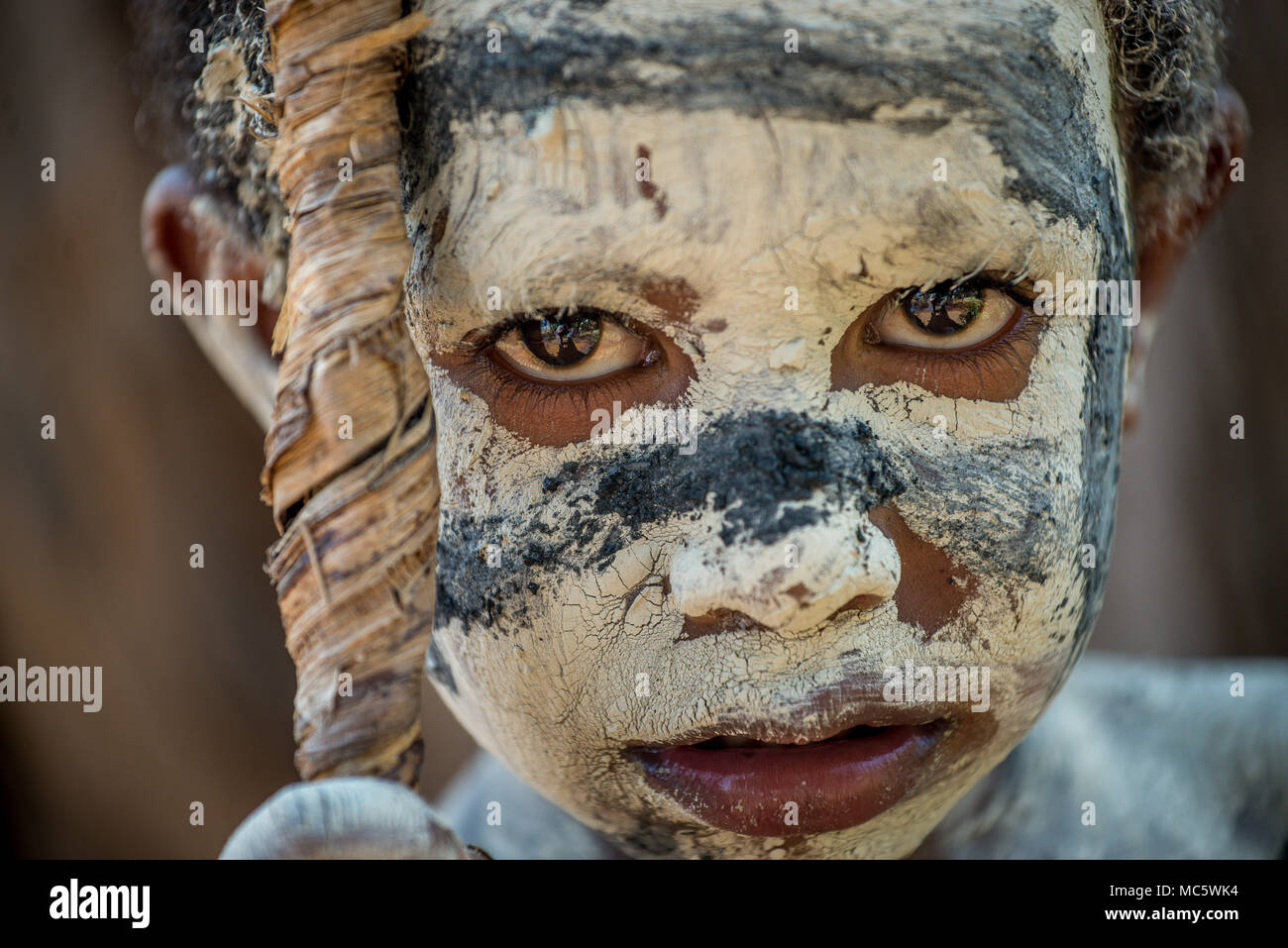 Close-up portrait of a young boy with face and body painting after a ...