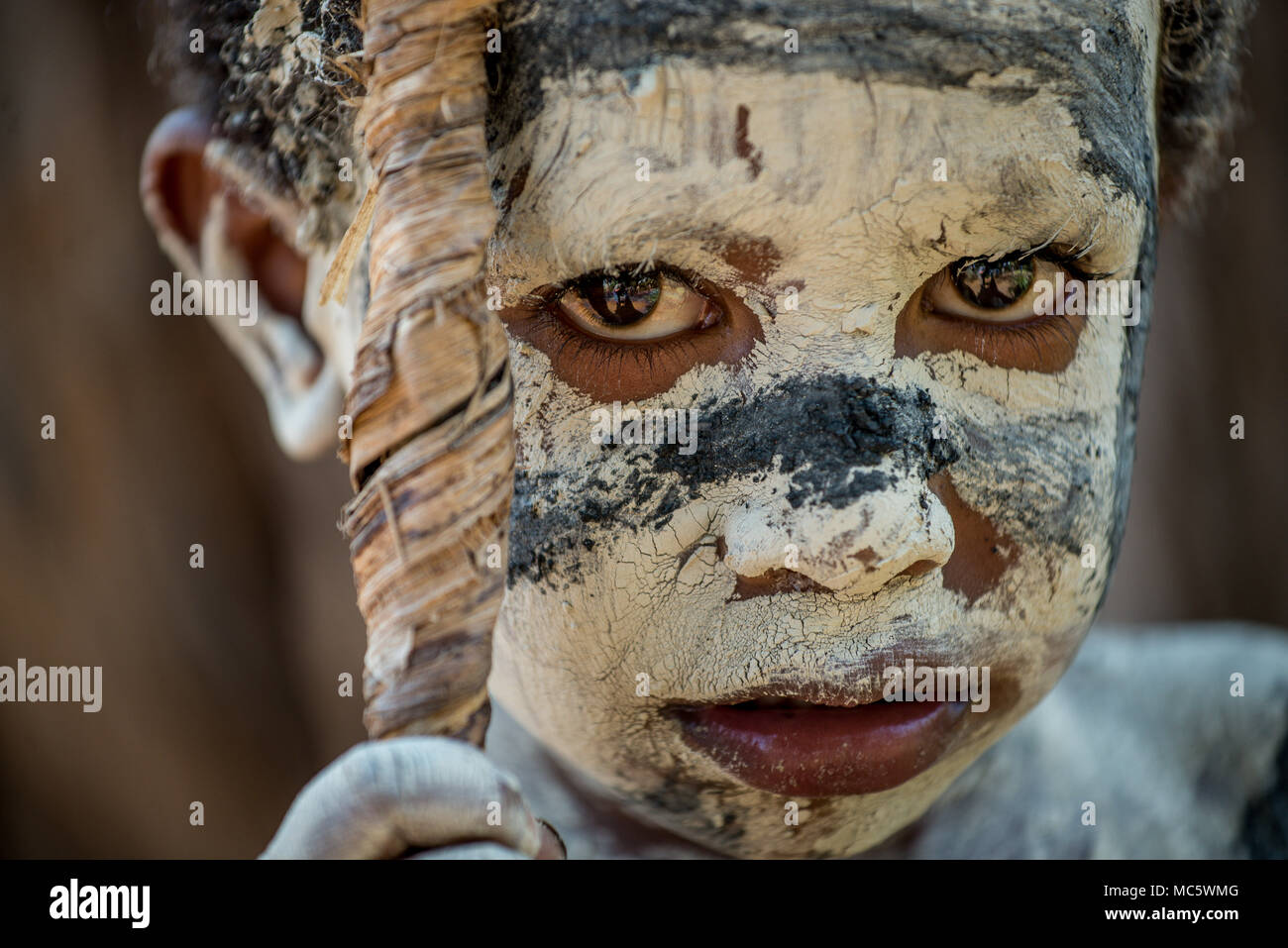 Close-up portrait of a young boy with face and body painting after a ...
