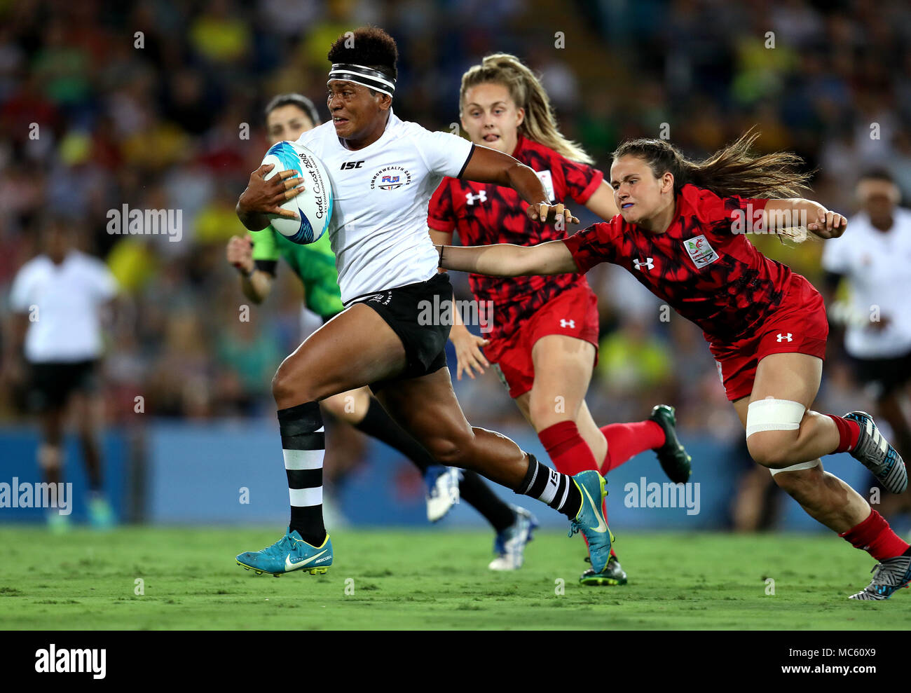 Fiji's Lavenia Tinai (left) scores a try and is chased by Wales ...
