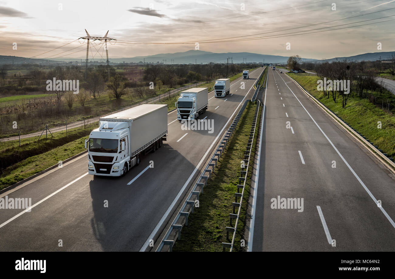 Caravan or convoy of trucks in line on a country highway Stock Photo ...