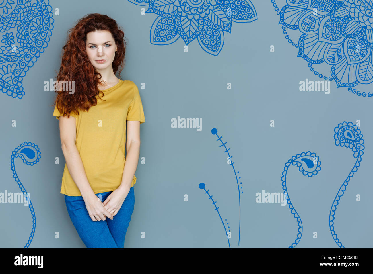 Young beautiful model standing next to the wall and posing for a photo ...
