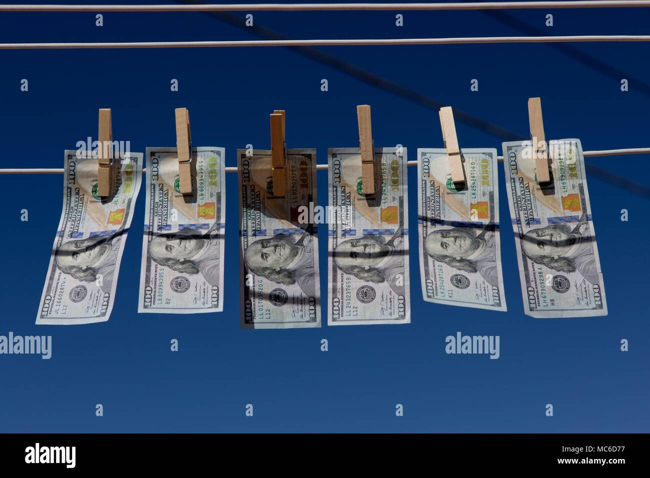 A bunch of 100 Dollar notes on a laundry drying rack standing out ...
