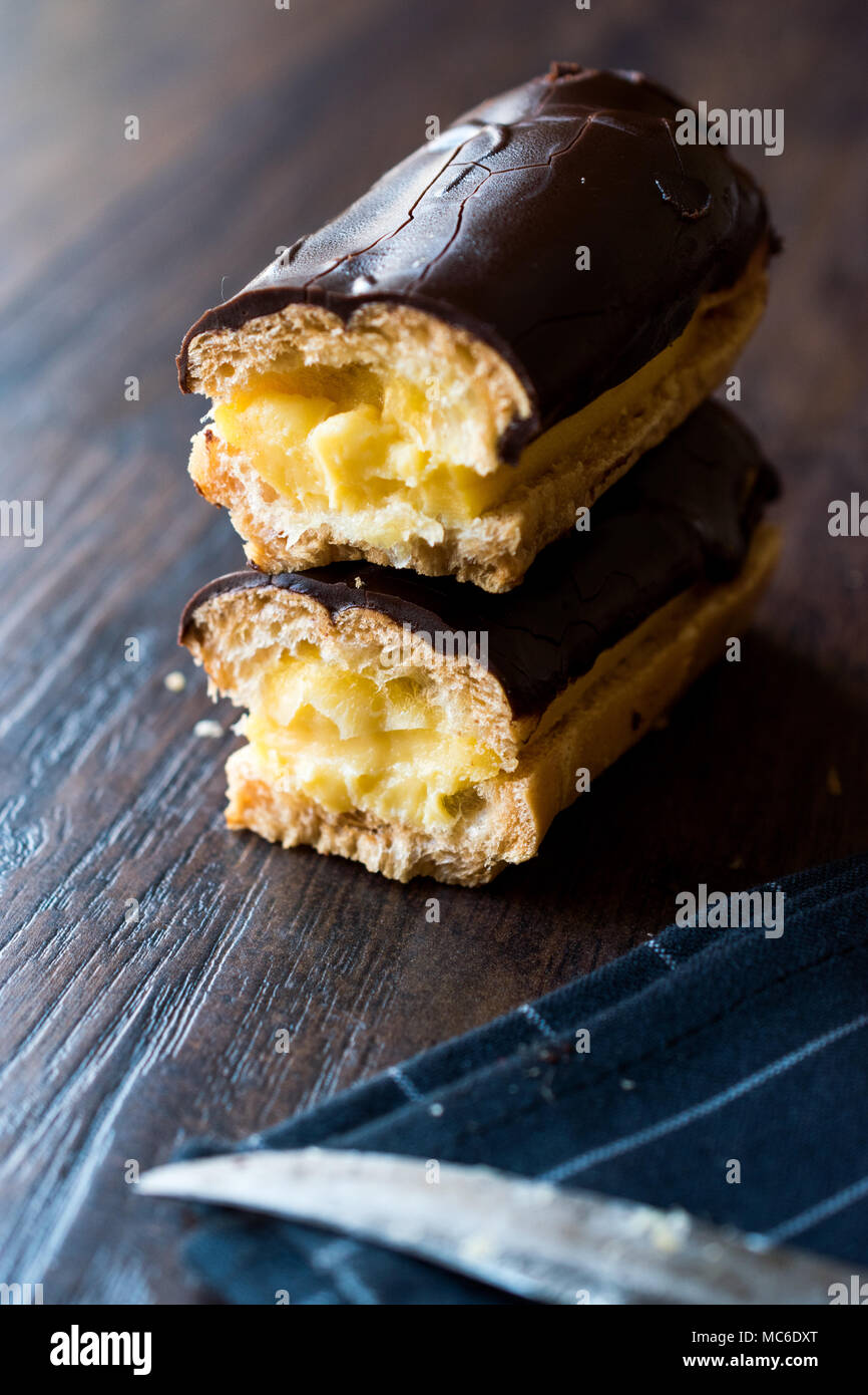 Half Cut Cream Filled Chocolate Eclairs on Dark Wooden Surface. Dessert ...