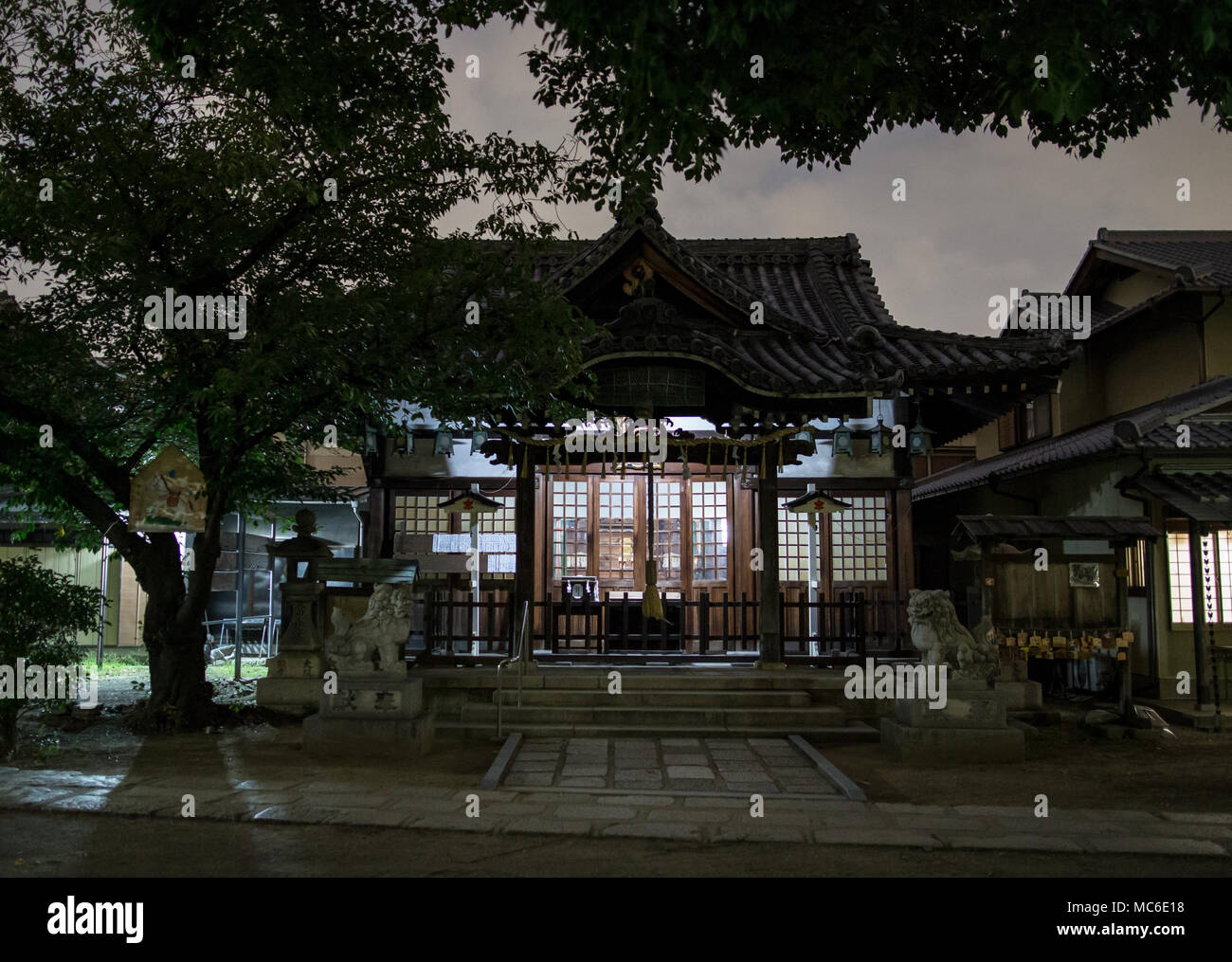 Small Japanese urban temple with lights on at night Stock Photo - Alamy