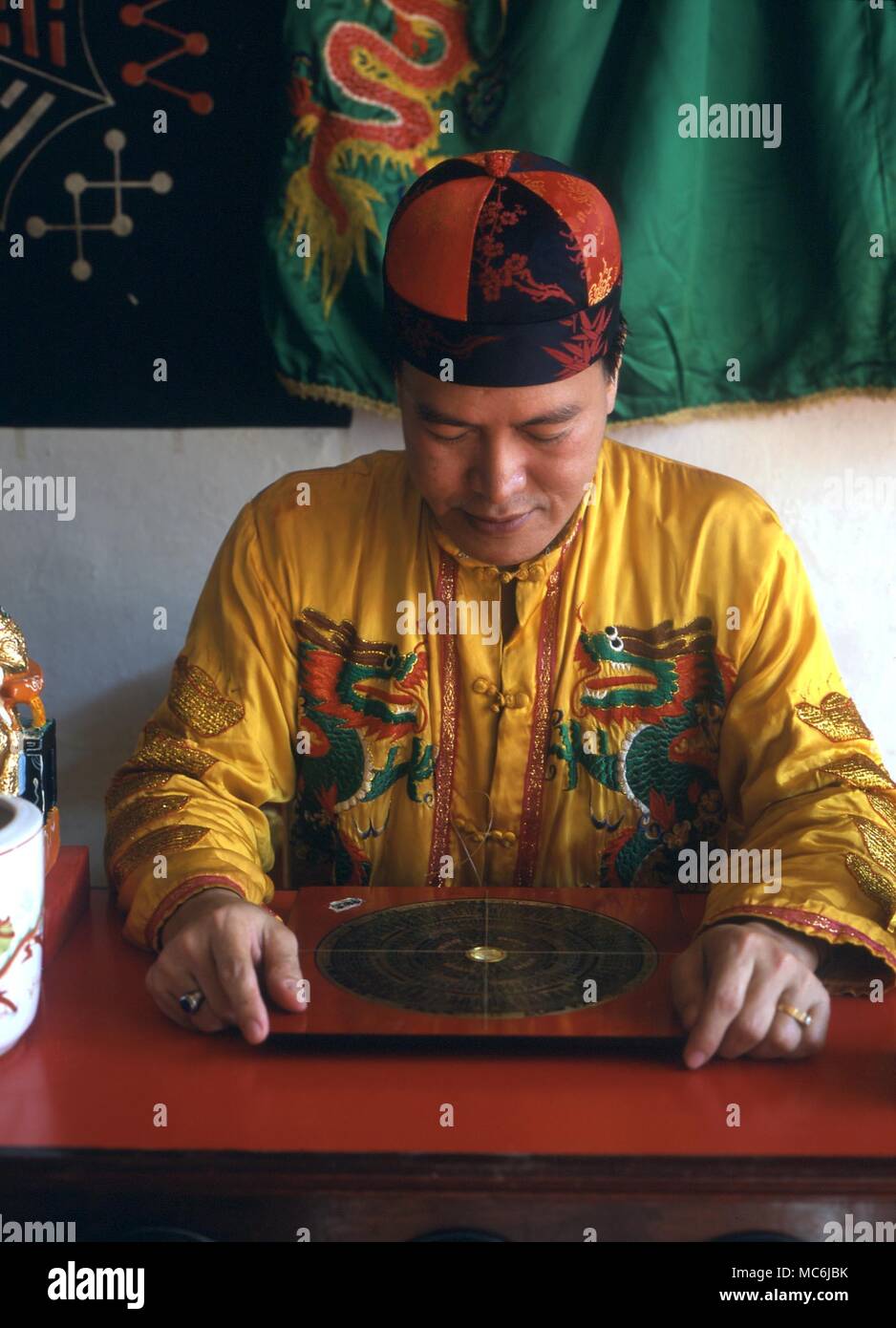 FENG SHUI. Chinese diviner using the geomancer compass, the Lo Pan, to ...