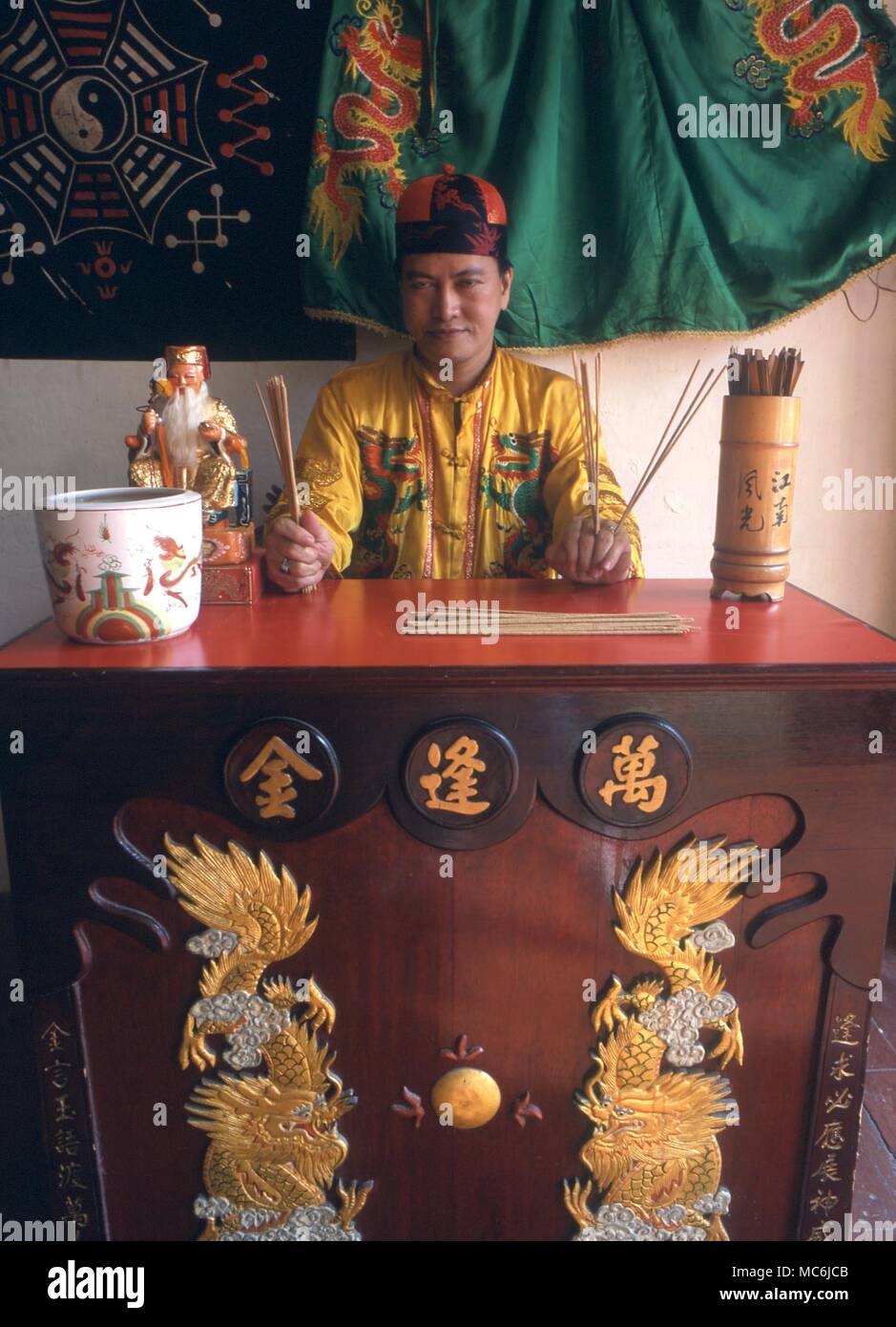 I CHING. Practitioner (diviner) of the I Ching, using sticks, in a ...