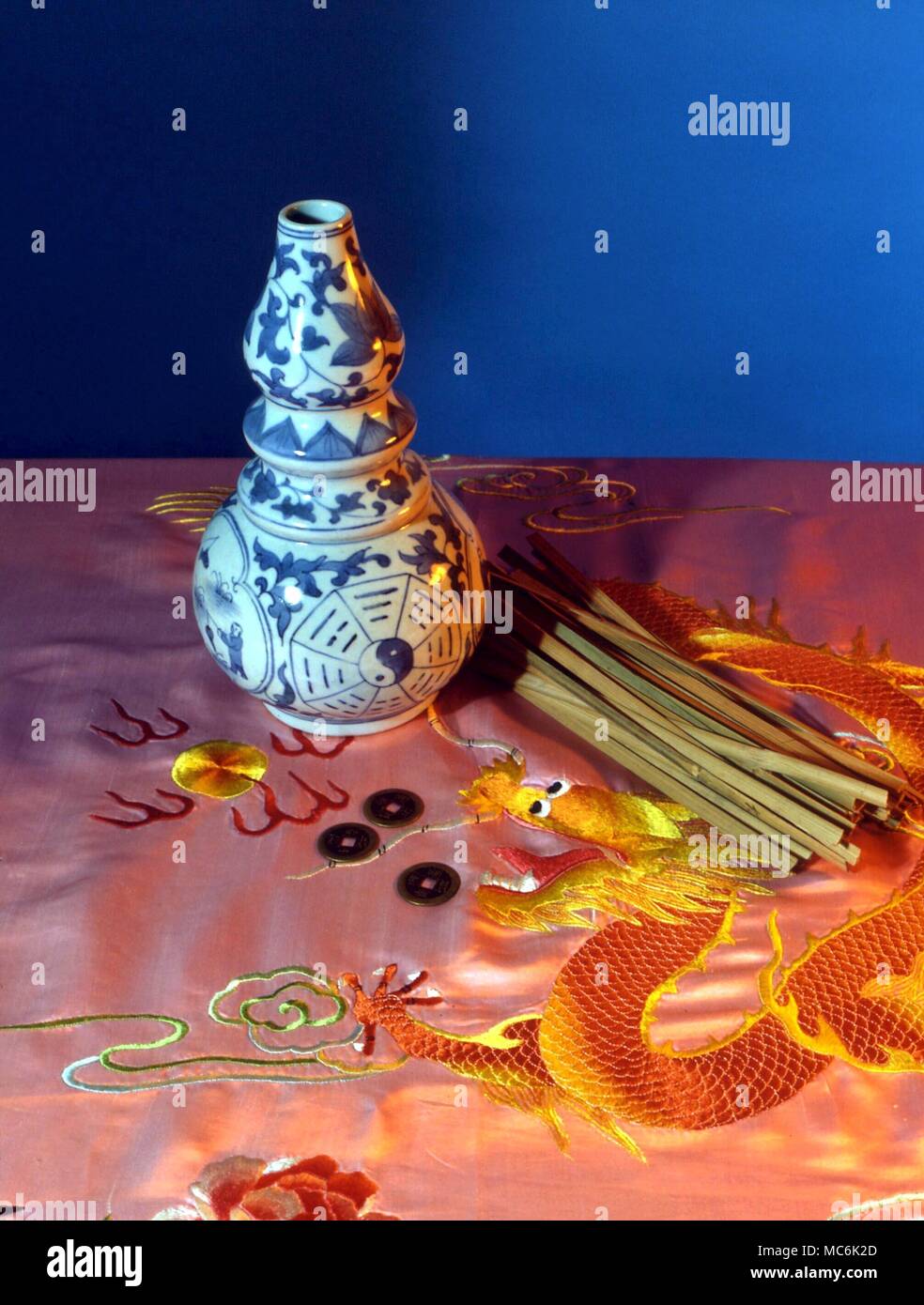 I CHING The yarrow stalks, coins and a vase with the Tai Chi symbol ...