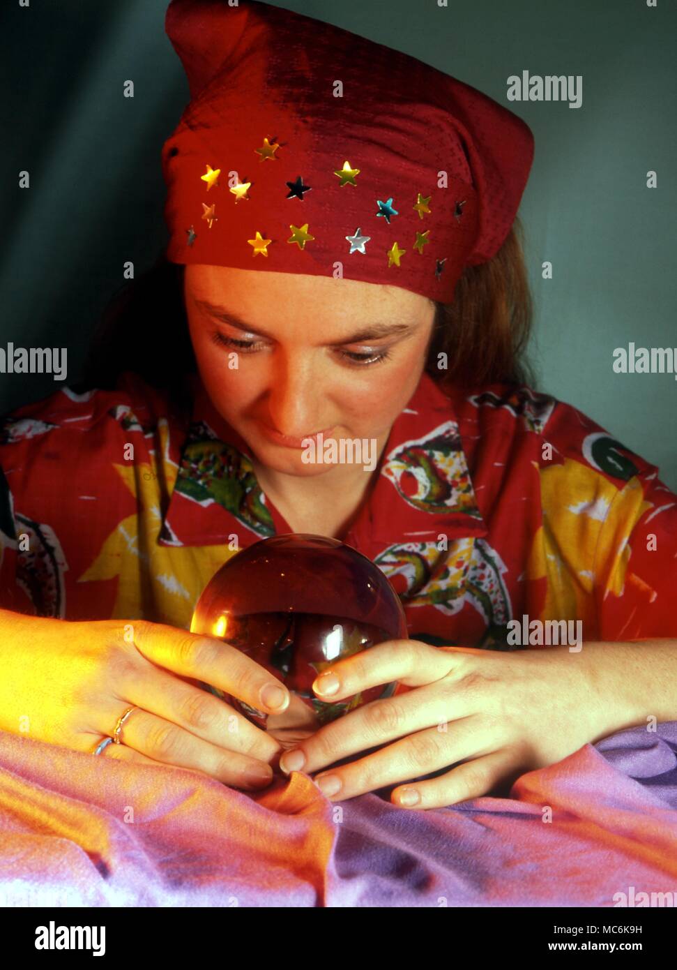 Crystal gazing. Young woman using a crystal ball for predicting the ...