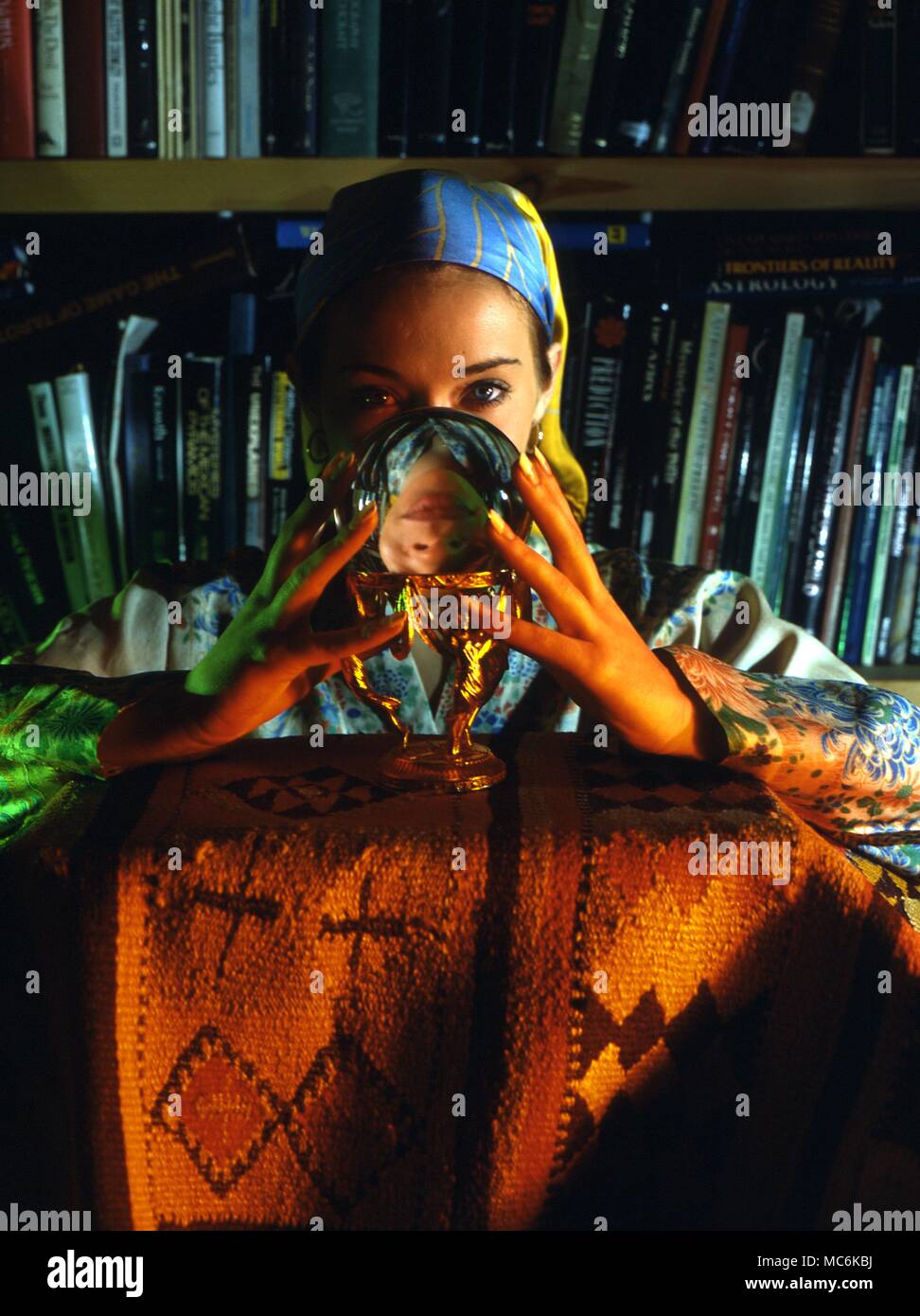 Crystal Gazing. Girl gazing into a crystal. It is mounted on a golden ...